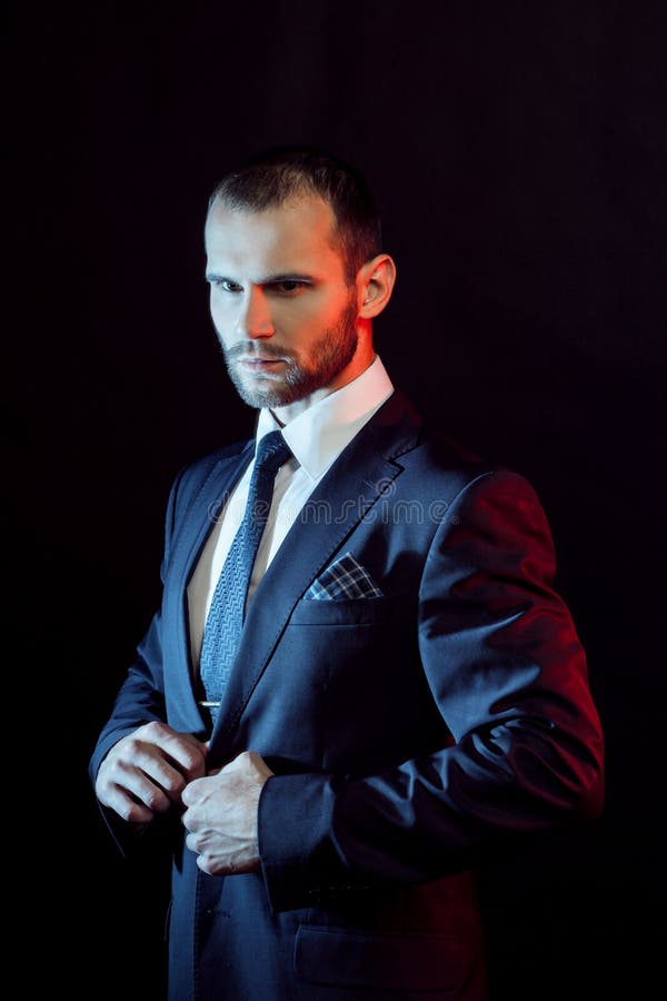 Serious Man in a Business Suit, Dark Background, Backlight Blue and Red ...