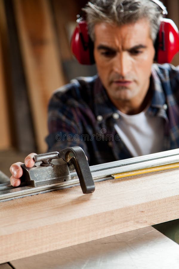 Serious Man Measuring a Piece of Wood Stock Photo - Image of occupation ...