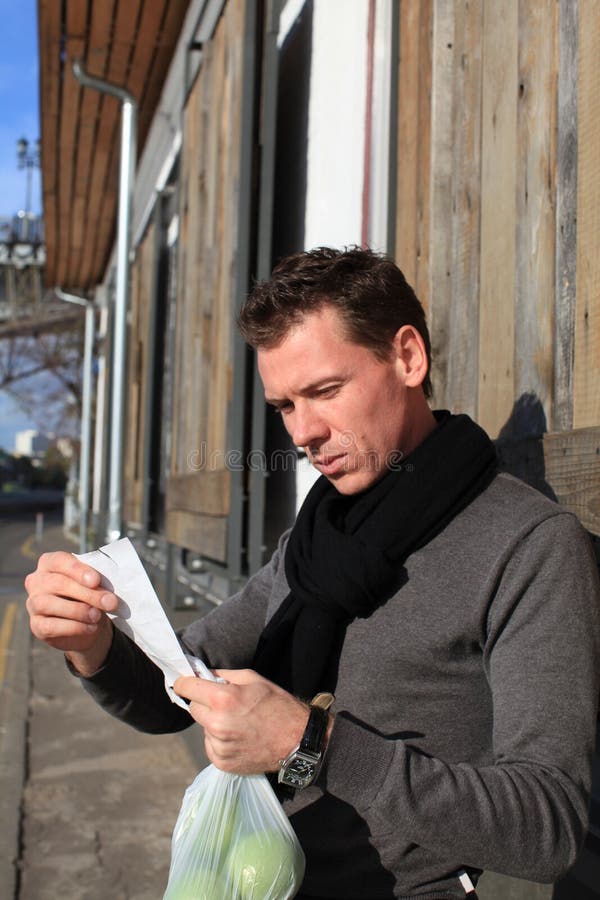 Serious man reading check stock image. Image of note - 16201327