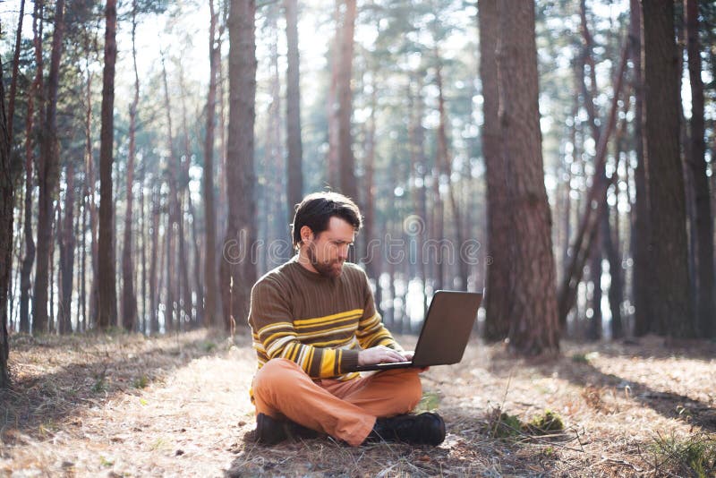 Serious Man Sitting Outdoors Using a Laptop Computer Stock Image ...