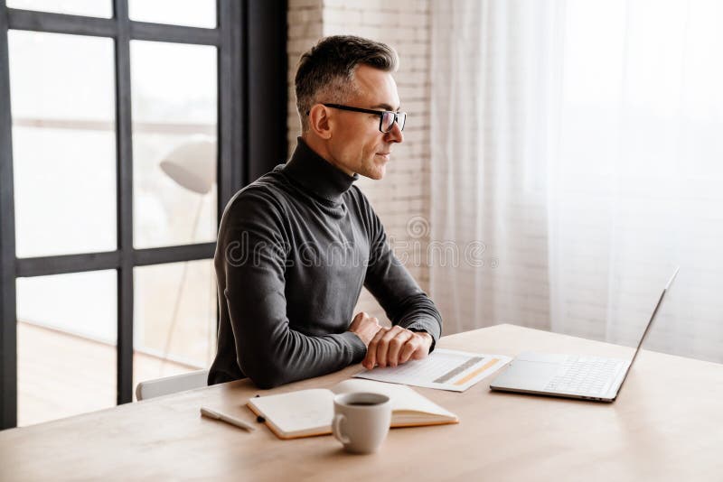 Serious Man Working with Laptop and Planner while Sitting at Table ...