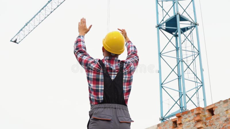 Serious Manager in Helmet and Uniform Giving Commands To Crane Operator ...