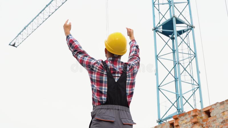 Serious Manager in Helmet and Uniform Giving Commands To Crane Operator ...