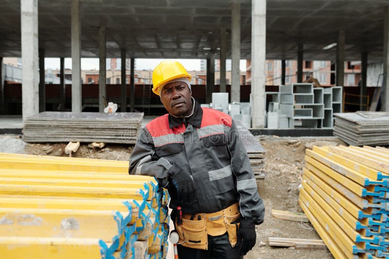 Serious Mature Black Man in Workwear and Protective Helmet Looking at ...
