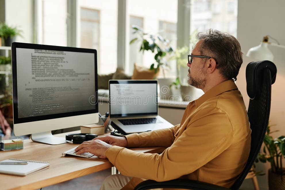 Serious Mature Software Developer Looking at Code on Screen Stock Photo ...