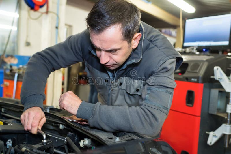 Serious mechanic at work stock photo. Image of tool - 253358140