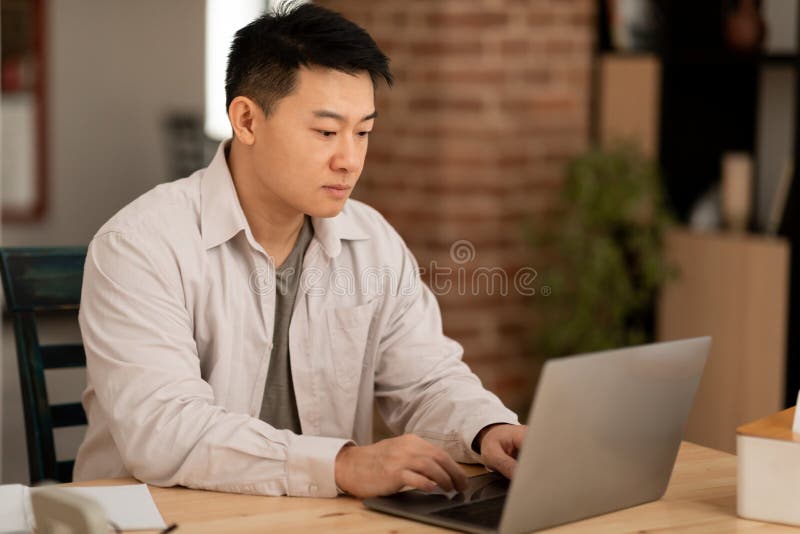 Serious Middle Aged Asian Man Using Laptop Computer, Typing on Keyboard ...