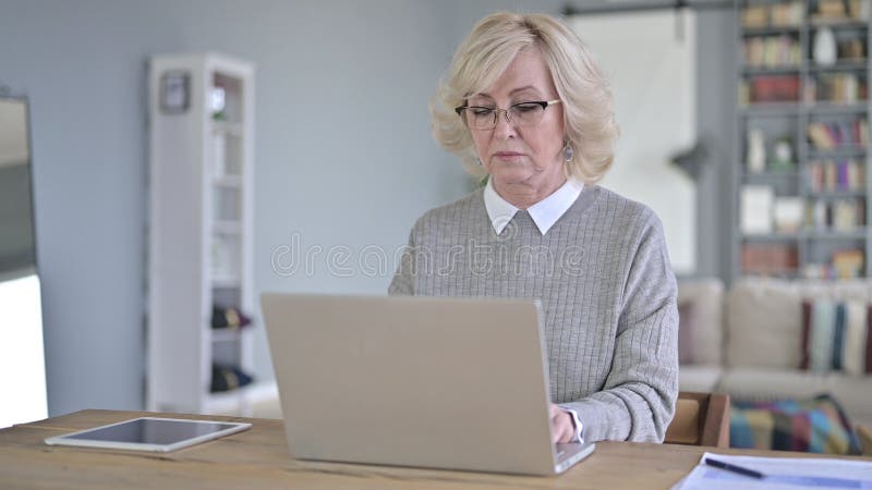 Serious Old Woman Using Laptop in Modern Office Stock Photo - Image of ...