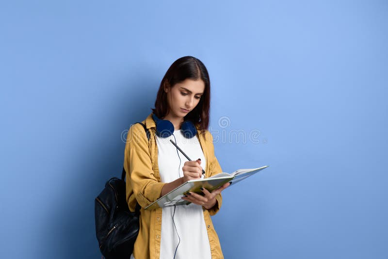 Serious Pretty Student Girl is Making Notes in Book after Classes in ...