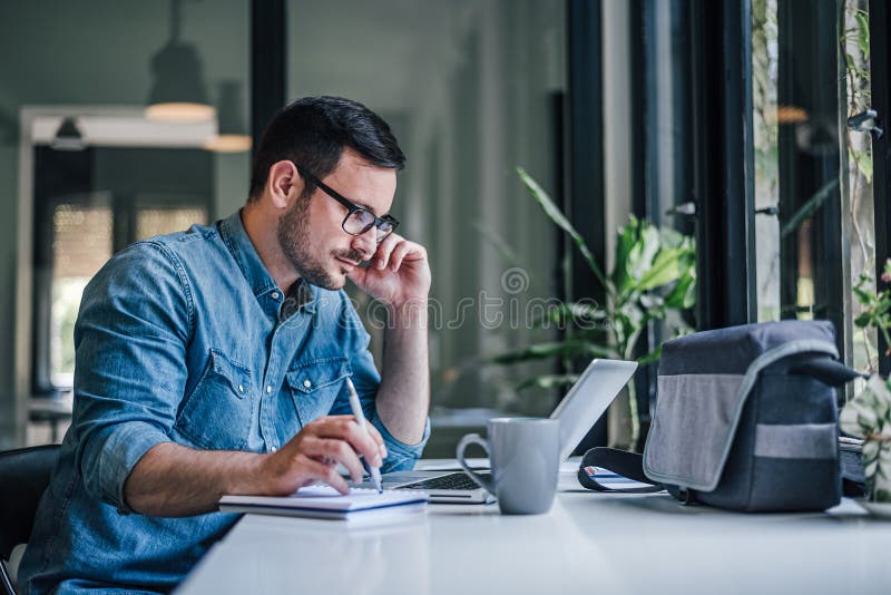 Serious Professional Planning Strategy while Using Laptop at Table in ...