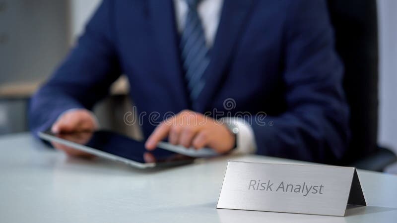 Serious Risk Analyst Working on Tablet Computer, Counting New Project ...