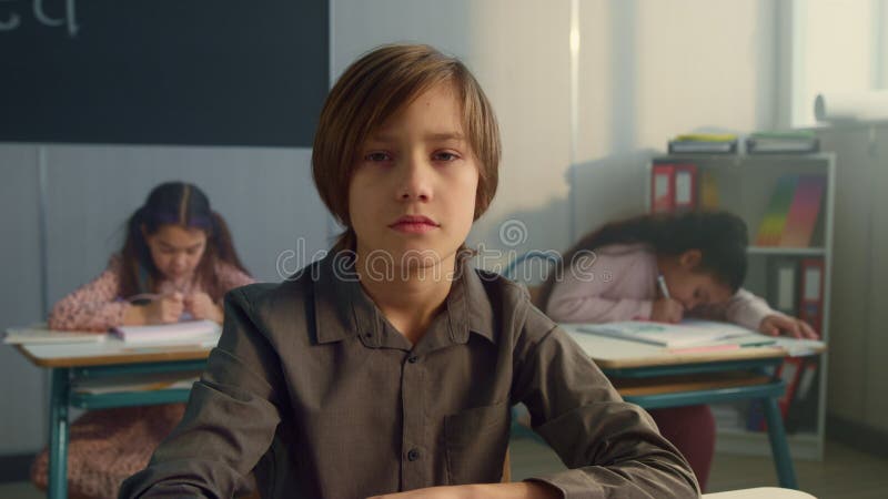 Serious Schoolboy Looking at Camera in Classroom. Focused Kid Sitting ...