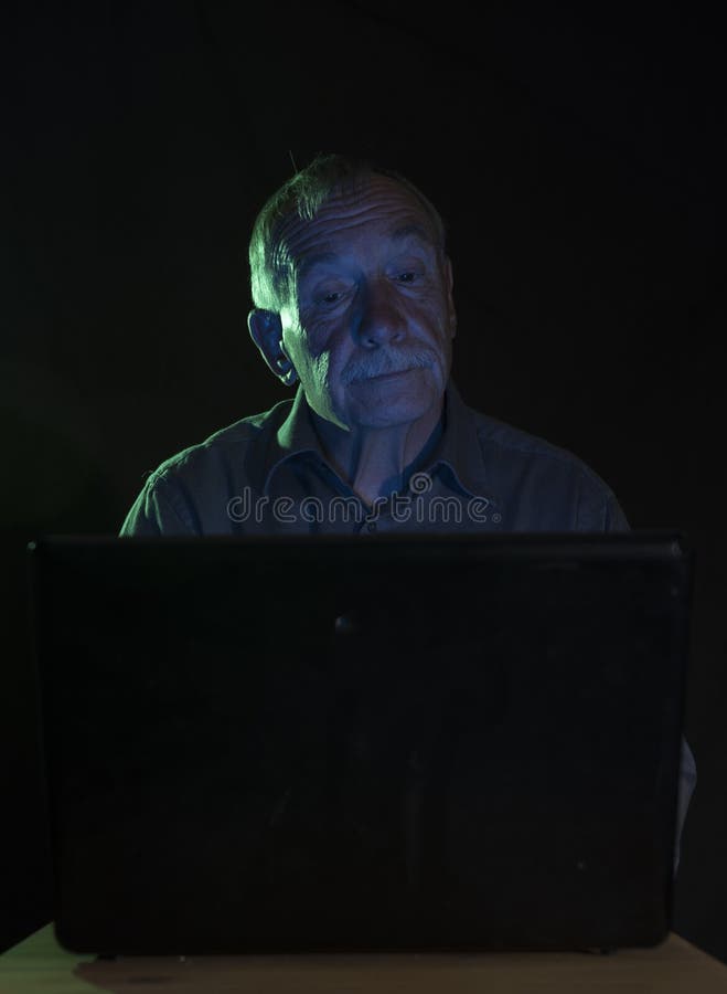 Mature Man Looking Out Of A Window With Blinds Casting Shadows Stock ...