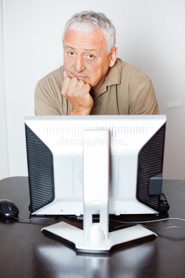 Serious Senior Man Sitting at Computer Desk in Class Stock Photo ...