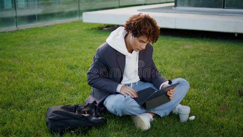 Serious Student Typing Laptop at Urban Park. Relaxed Youngster Sitting ...