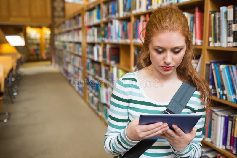 Serious Student Using Tablet Standing in Library Stock Photo - Image of ...