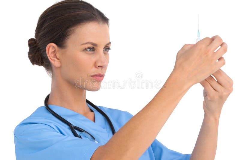 Serious Surgeon Holding Up a Syringe and Checking it Stock Photo ...