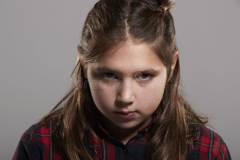 Serious Ten Year Old Girl Looking To Camera Head And Shoulders Stock