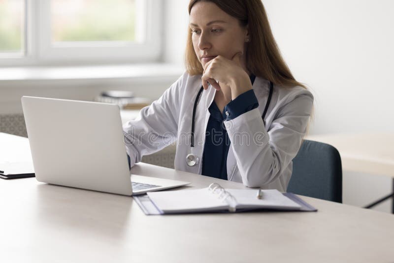 Serious Thoughtful Practitioner Woman Working at Computer in Office ...