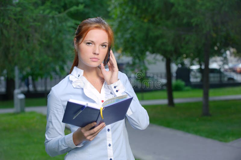 Serious Woman with Notebook Talking on the Phone Stock Photo - Image of ...