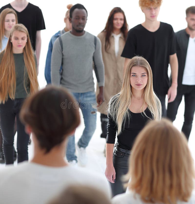 Serious Woman Standing in Front of Casual Group of Young People Stock ...