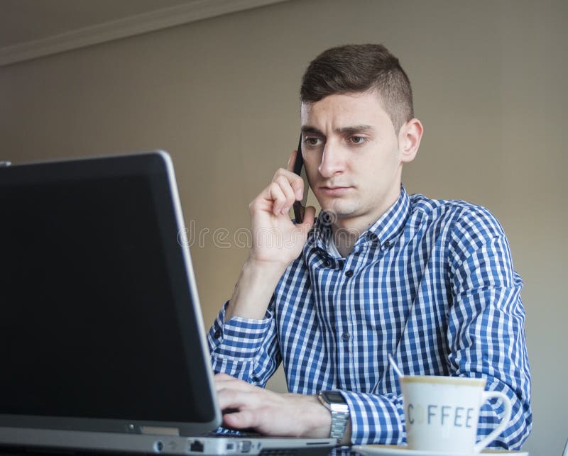 Serious Young Business Man Speaking on Phone, Checking Data on Screen ...