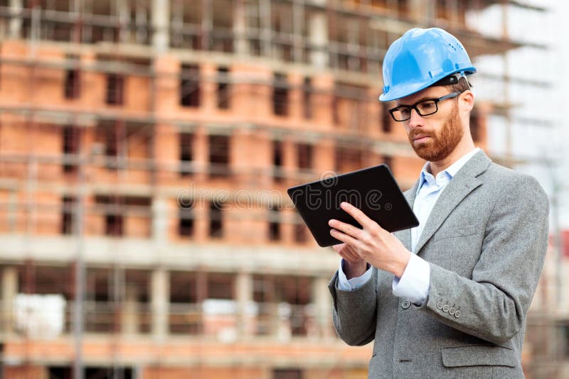 Young Architect or Civil Engineer Using a Tablet on a Construction Site ...