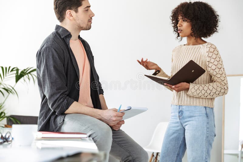 Serious Young Colleagues Talking and Working Together Stock Image ...
