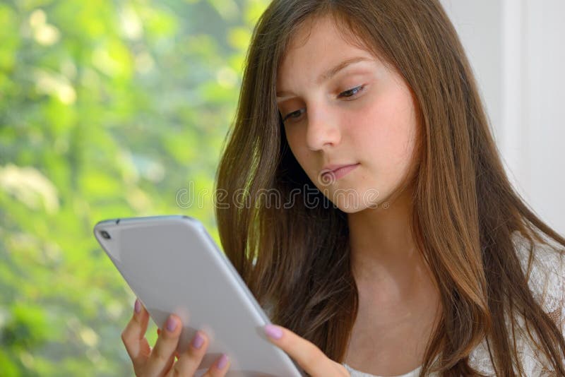 Serious Young Girl Reading on a Tablet Computer Stock Image - Image of ...