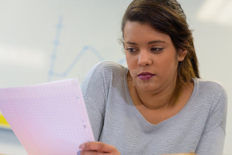 Serious Young Lady in Class Looking at Sheet Paper Stock Image - Image ...