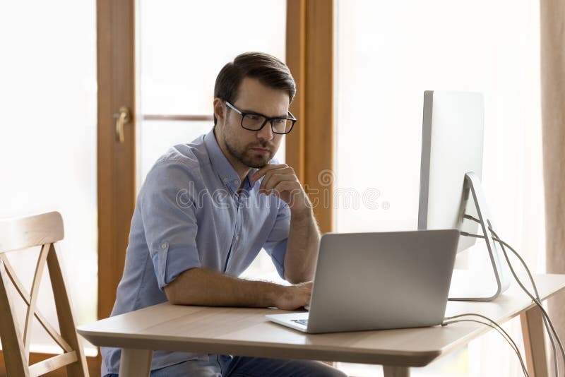 Serious Young Man Work from Home Office on Two Computers Stock Image ...
