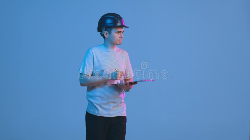 Serious Young Man in Helmet Checking Something. Studio Video on Blue ...