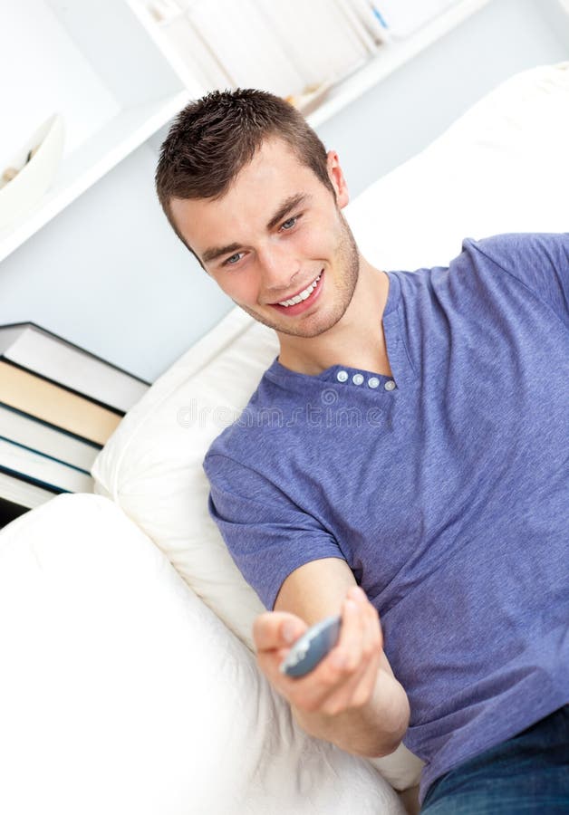 Serious Young Man Holding a Remote Sitting on Sofa Stock Photo - Image ...
