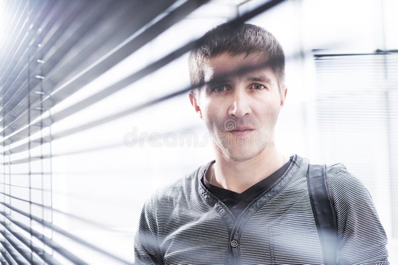 Serious Young Man Looking through Window Blind Stock Image - Image of ...
