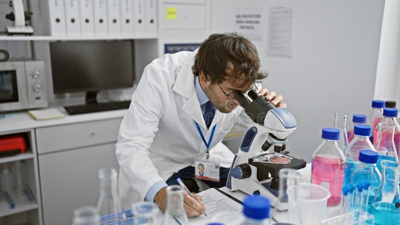 Serious Young Man Scientist, a Bearded Blond, Meticulously Taking Notes ...