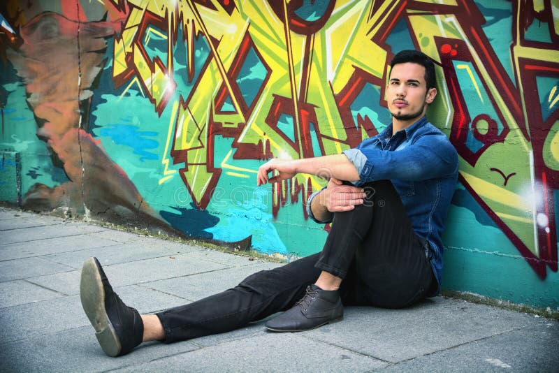 Serious Young Man Sitting Against Colorful Graffiti Wall Editorial ...