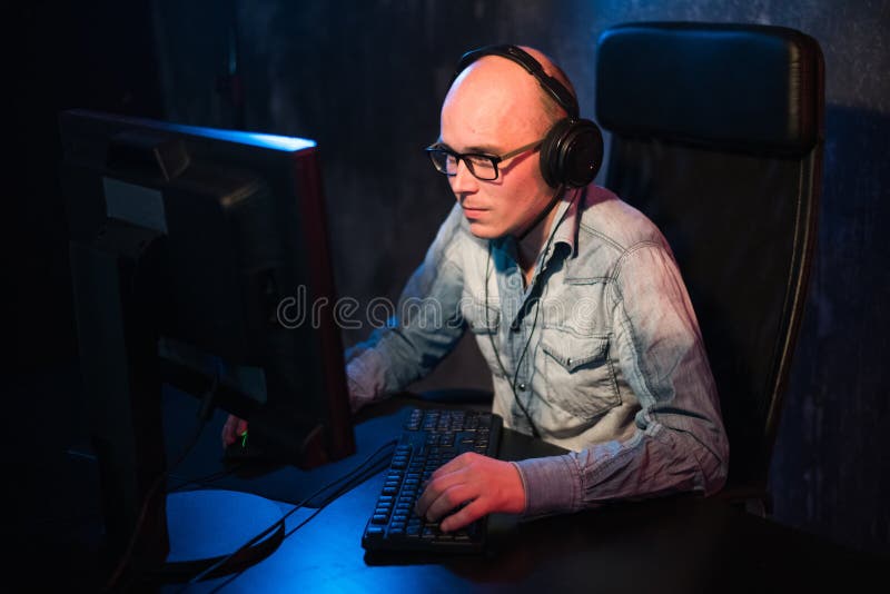 Serious Young Man Sitting and Working with Computer in Dark Office ...