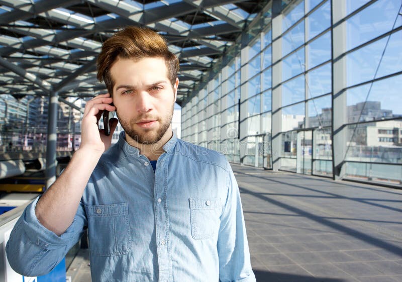 Serious Young Man Talking on Mobile Phone Inside Building Stock Photo ...