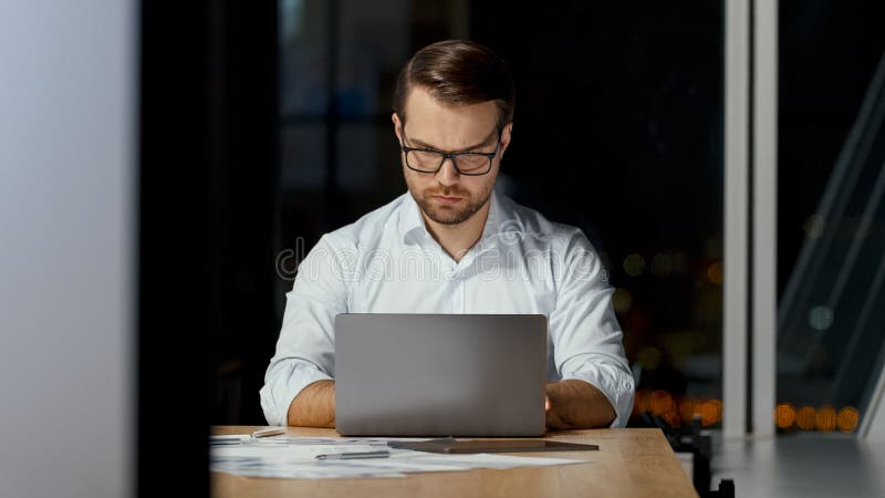 Serious Young Man Typing Message on Laptop Keyboard in Office Stock ...