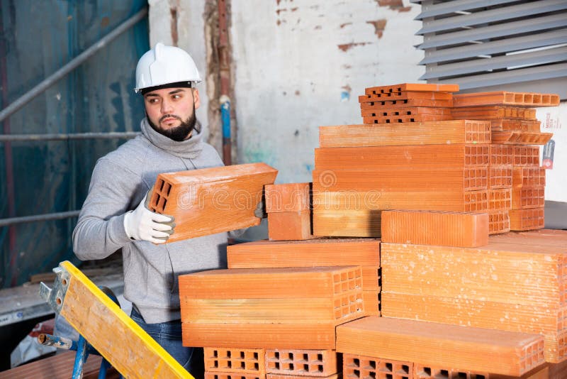 Man stacking red bricks stock image. Image of working - 213504691