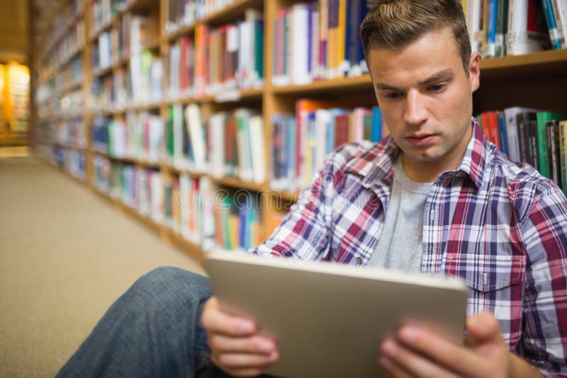 Serious Young Student Sitting on Library Floor Using Tablet Stock Image ...