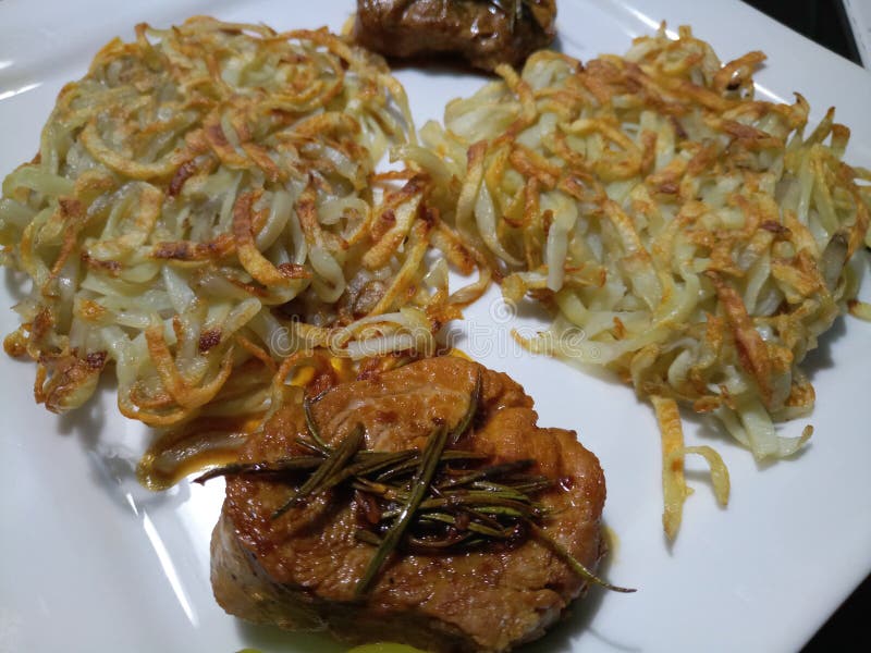 Two Piles of Crispy Stringy Potatoes and Pork Fillet Stock Image ...