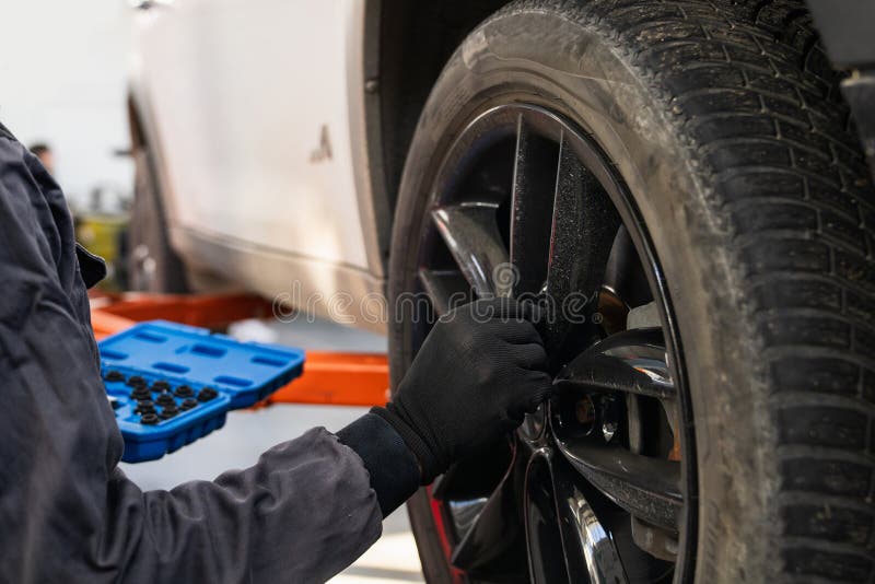 Serviceman Checks Car Suspension on a Column Lift in Car Service. Stock ...