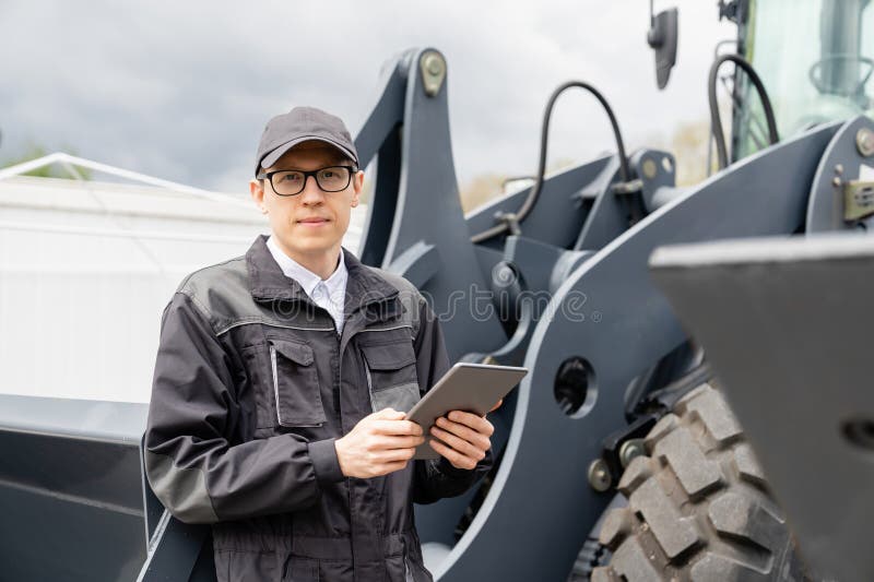 Serviceman with Digital Tablet on a Background of the Tractor Stock ...