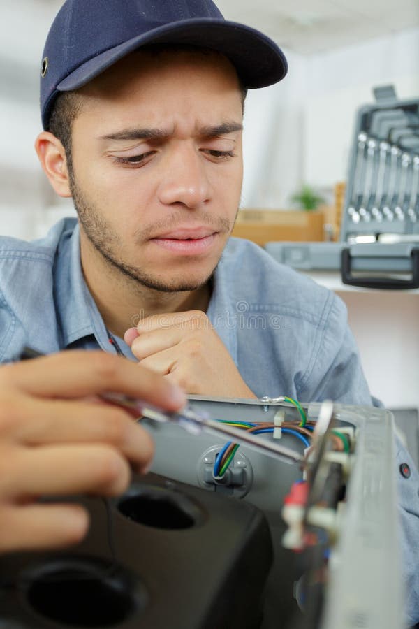 Serviceman Frowning while Trying To Test Appliance Stock Image - Image ...