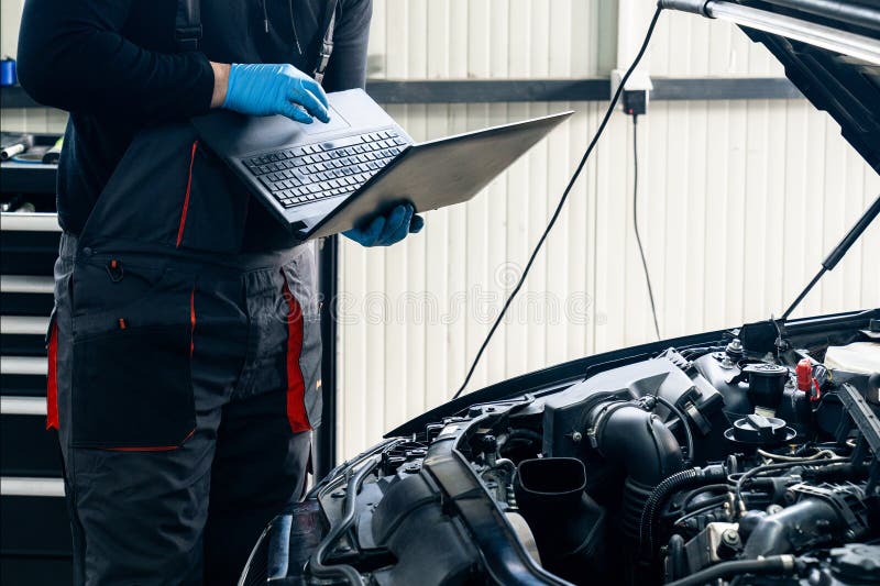 Serviceman with Laptop Checks Car Software in Car Service Stock Photo ...