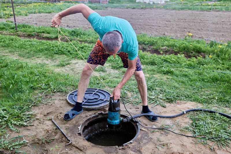 When Servicing a Septic Tank, a Man Uses a Submersible Wastewater Pump ...