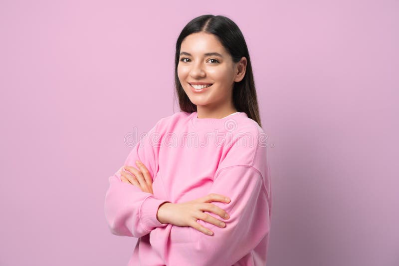 Serving Looks and Confidence. Young Woman in a Pink Pullover, Arms ... Serving Looks and Confidence. Young Woman in a Pink Pullover, Arms ...