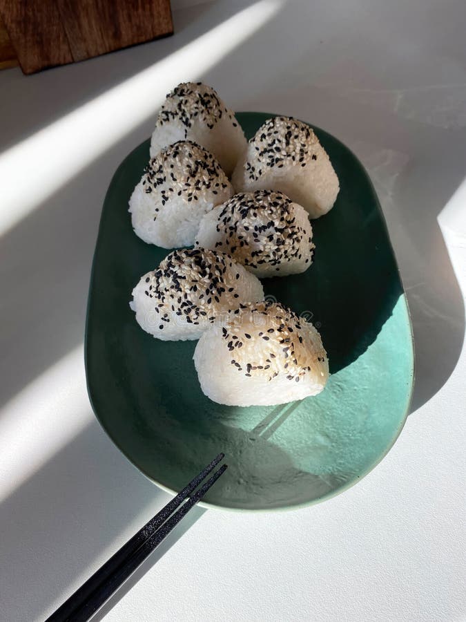Sesame Rice Onigiri on a Plate in the Sunshine on a White Table. a ...