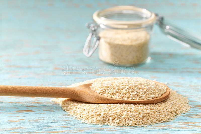 Sesame in a Wooden Spoon and Open Glass Jar on a Blue Wooden Background ...
